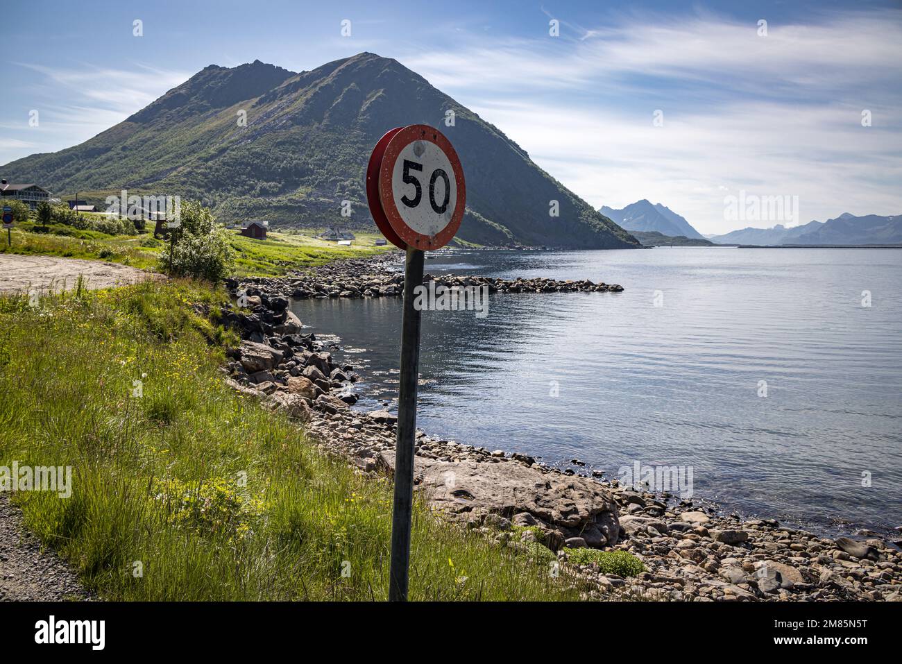 Speed limit sign by lake and mountains at Hoydalen, Vesteralen ...