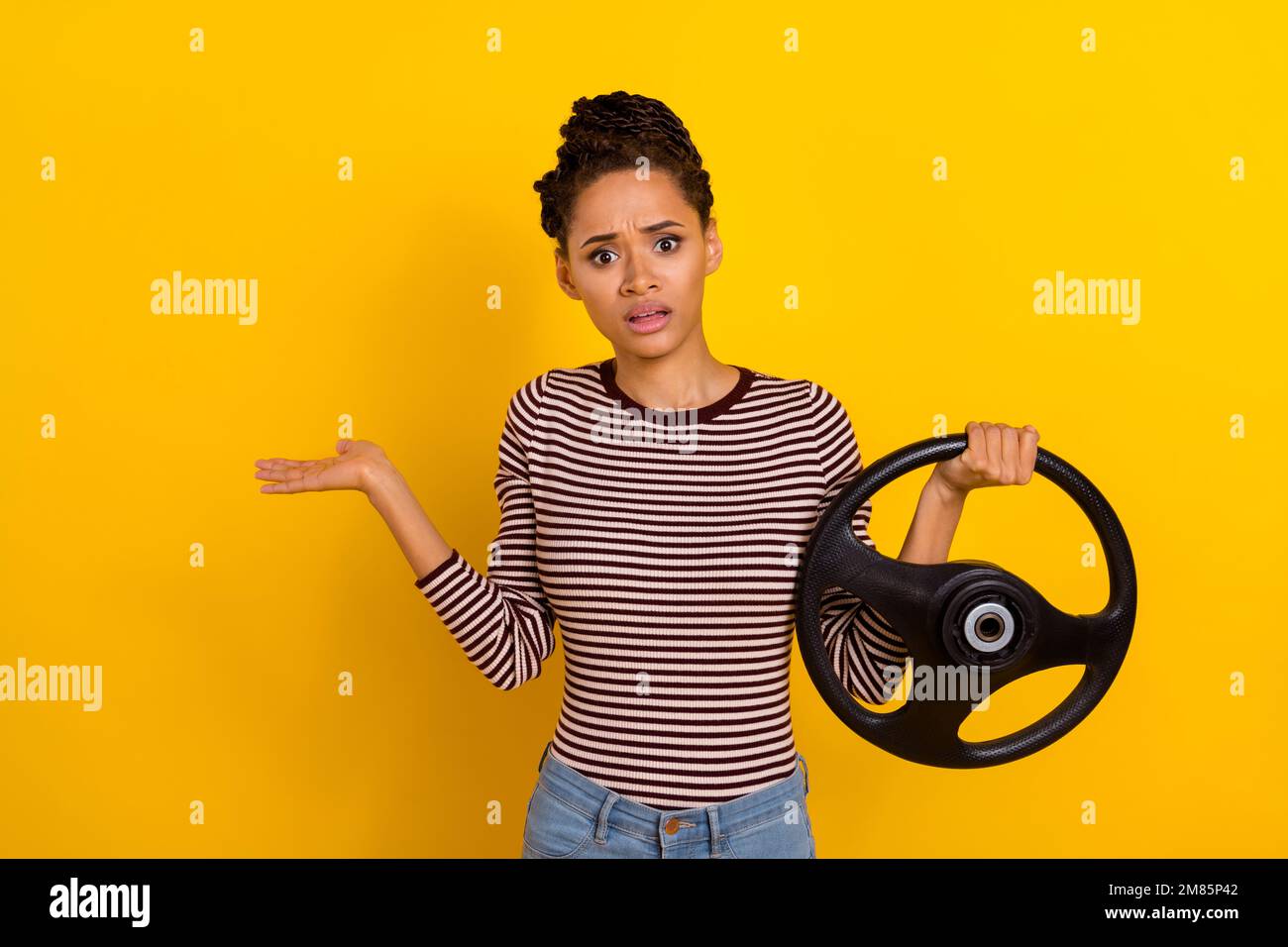 Portrait of clueless young person shrug shoulder hand hold wheel ...