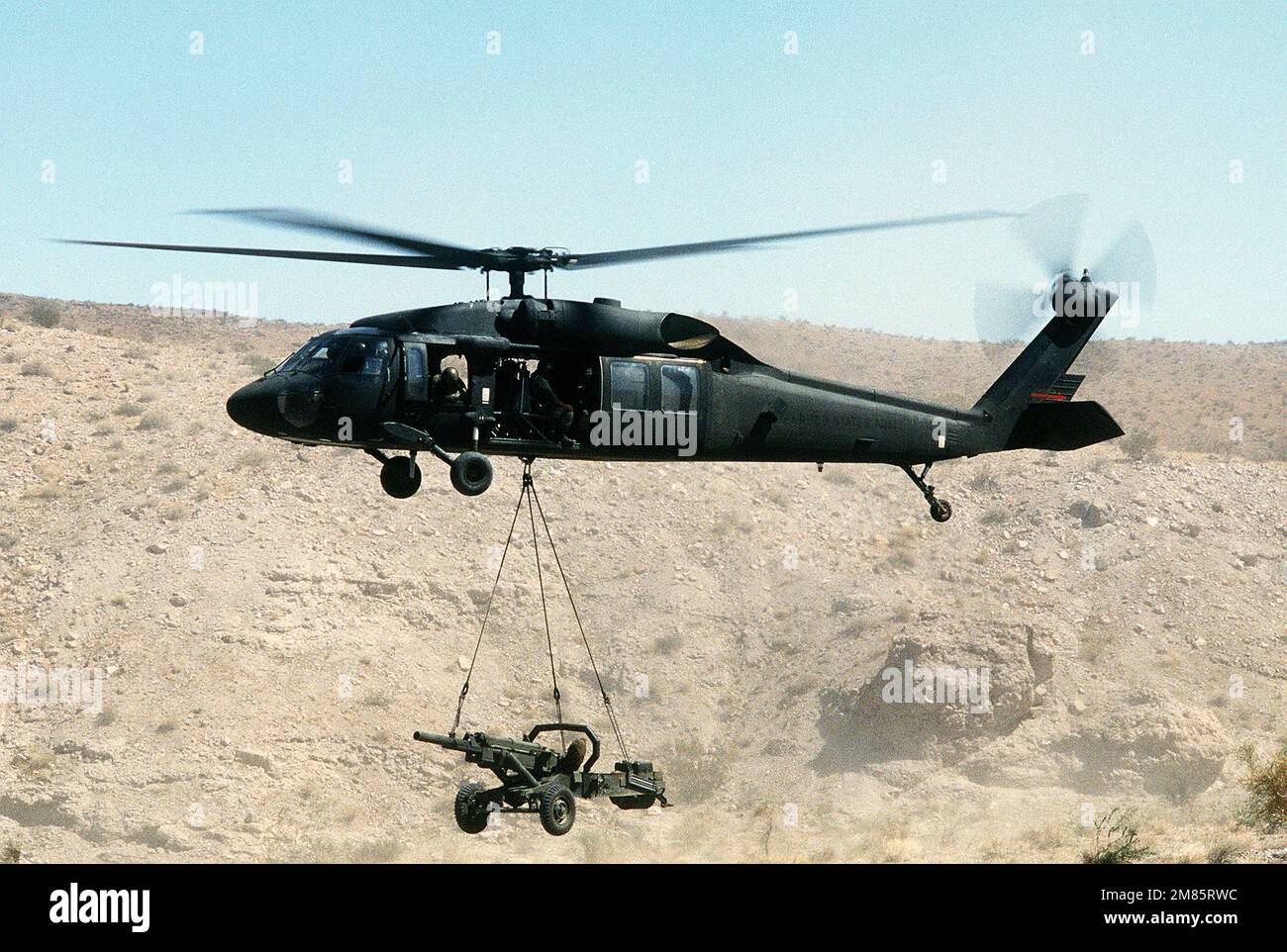 An M-102 105mm howitzer is airlifted by a 101st Airborne Division UH ...