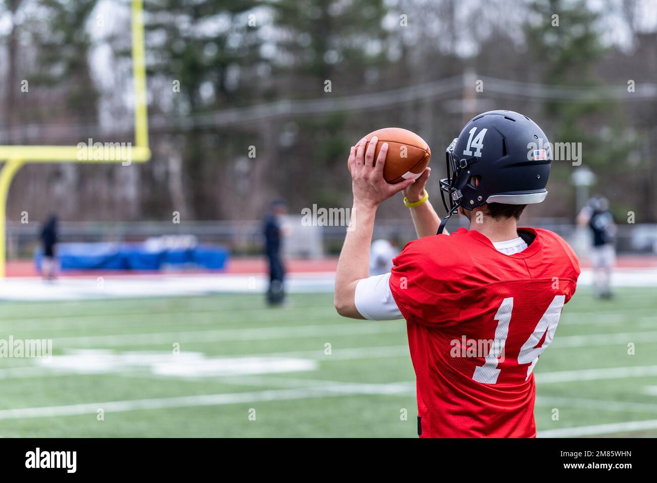 A young football player catching a ball Stock Photo - Alamy