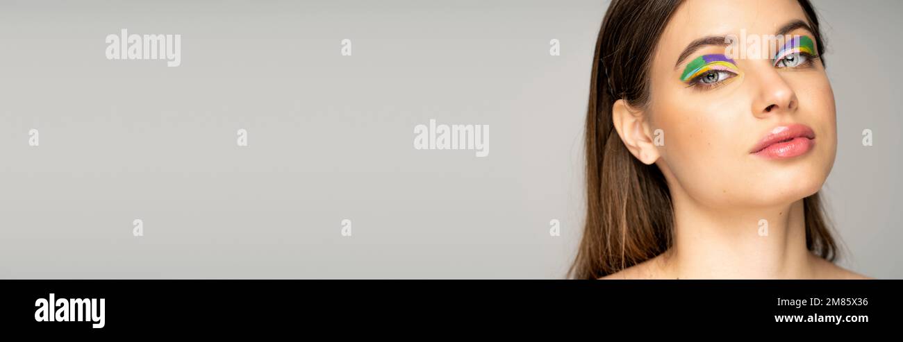 Portrait of teenage girl with colorful visage looking at camera ...