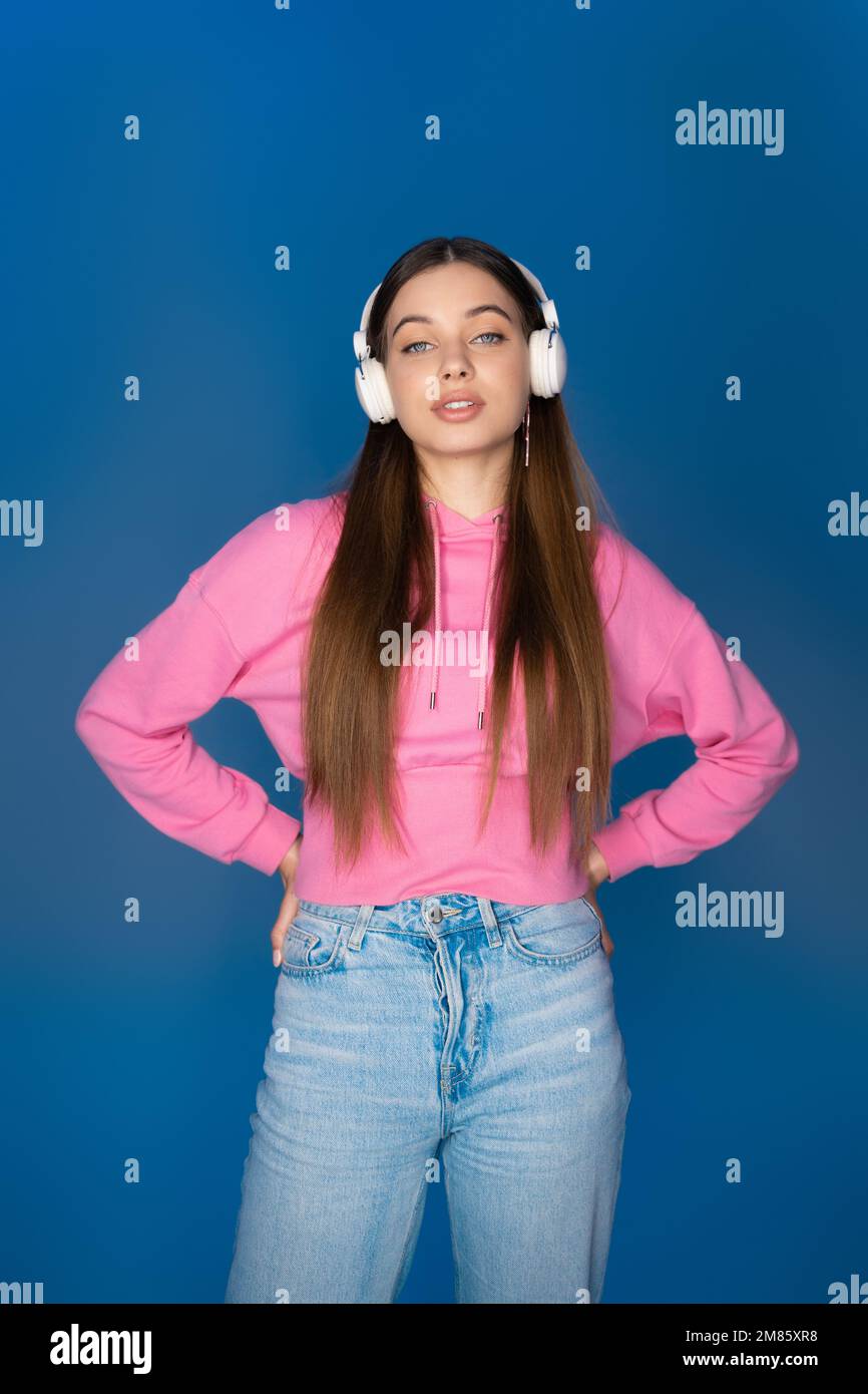 Teen girl in jeans and hoodie listening music in headphones isolated on ...