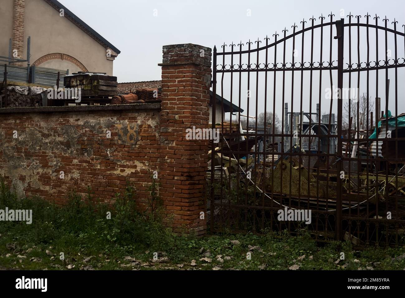 Gate in a brick boundary wall at the edge of a road with building ...