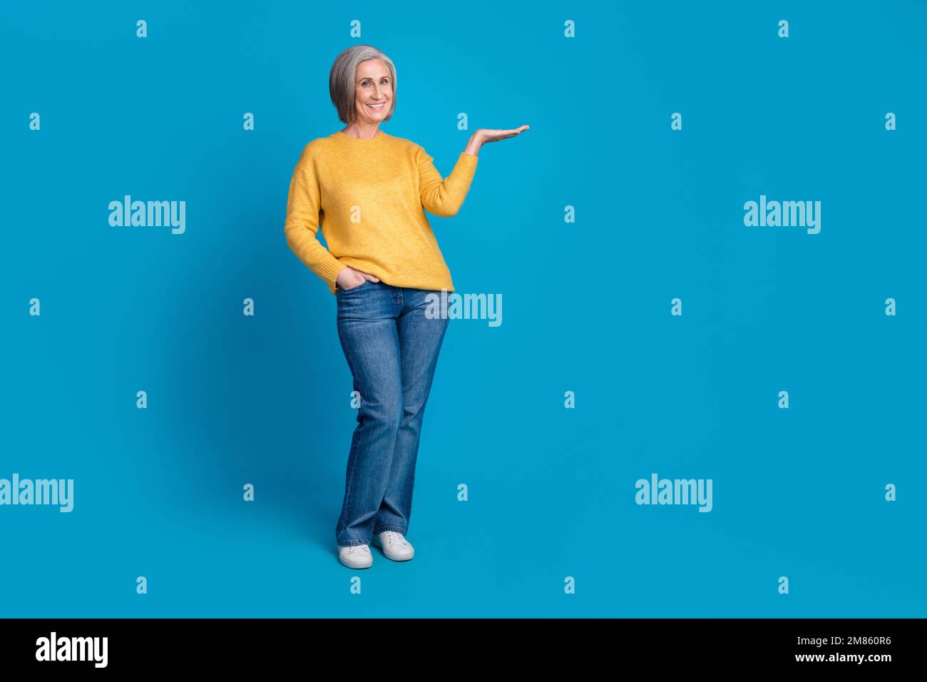 Full size photo of cheerful glad girl arm palm hold empty space ...