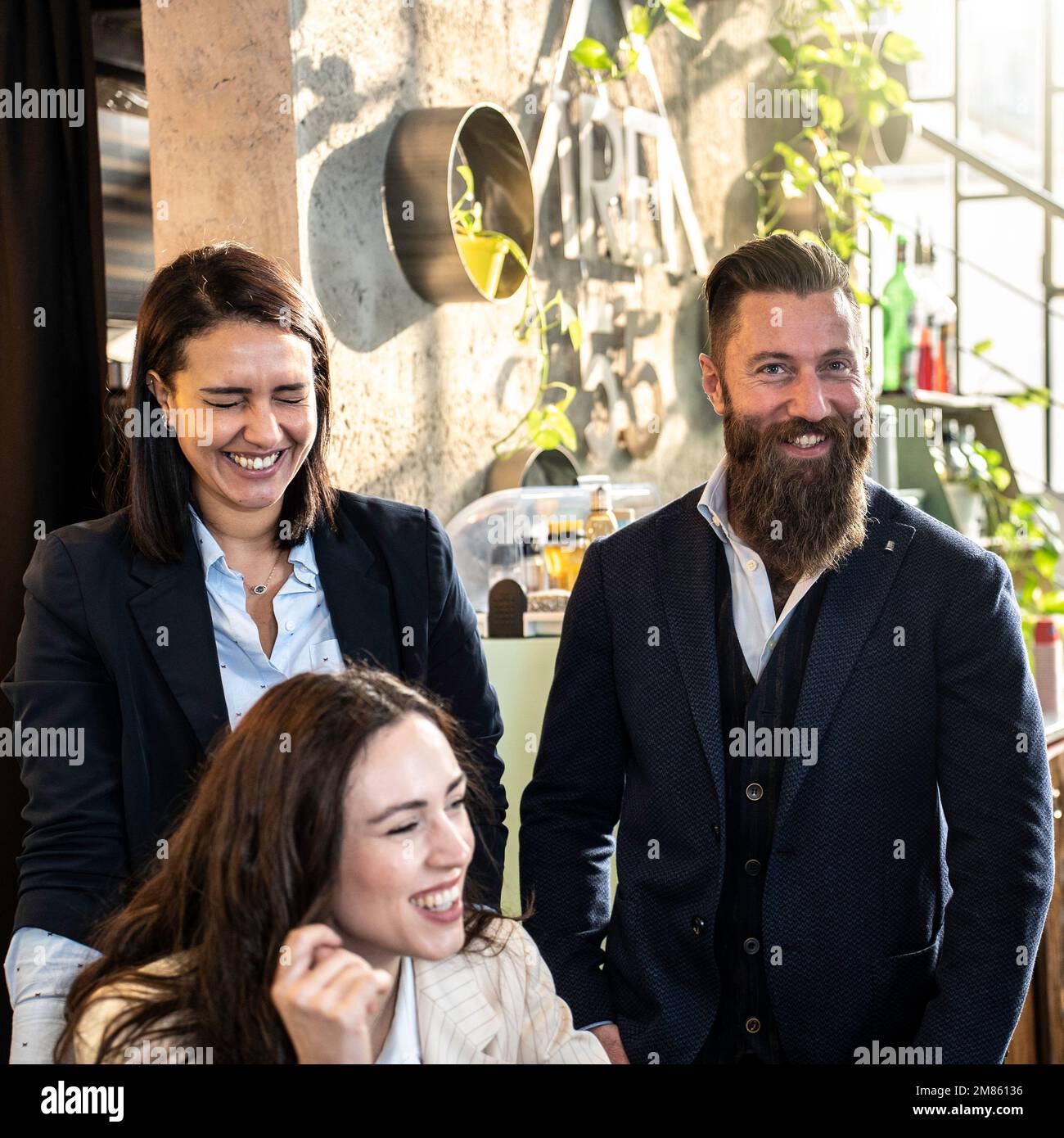 Colleagues laughing together during a break in the modern office ...