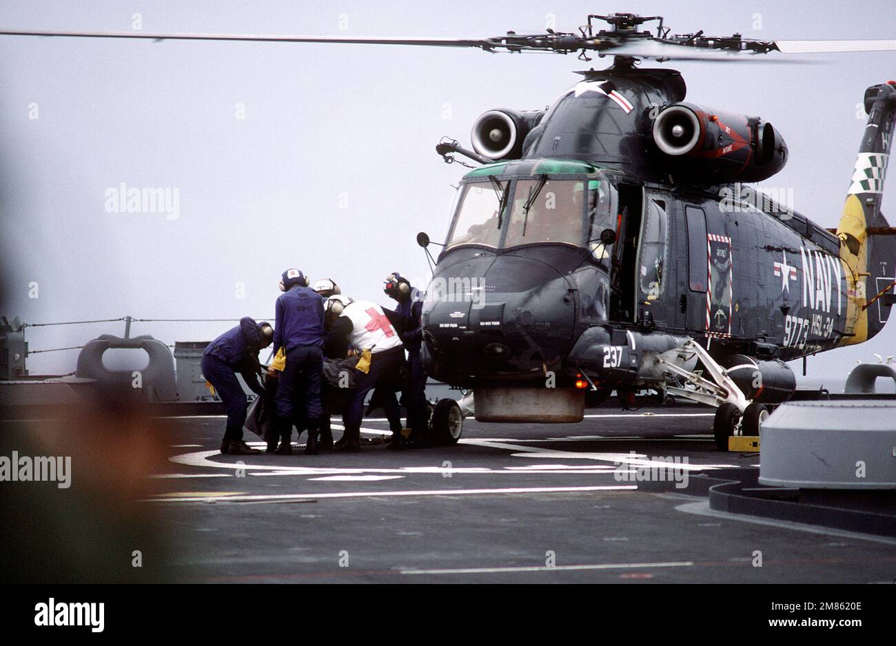 Crew members aboard the battleship USS IOWA (BB-61) assist in unloading ...