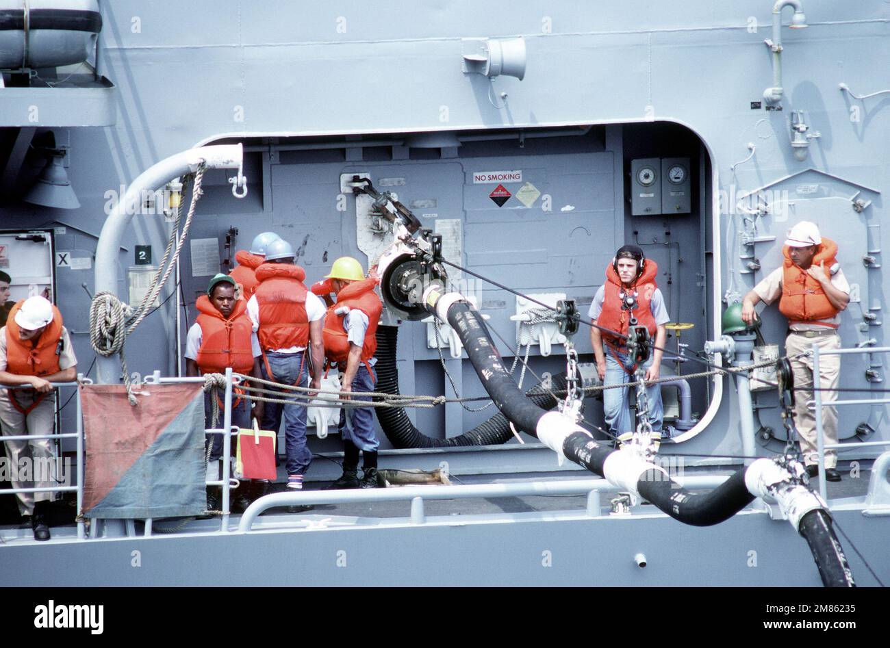 Crew members stand by at refueling station aboard the destroyer USS ...