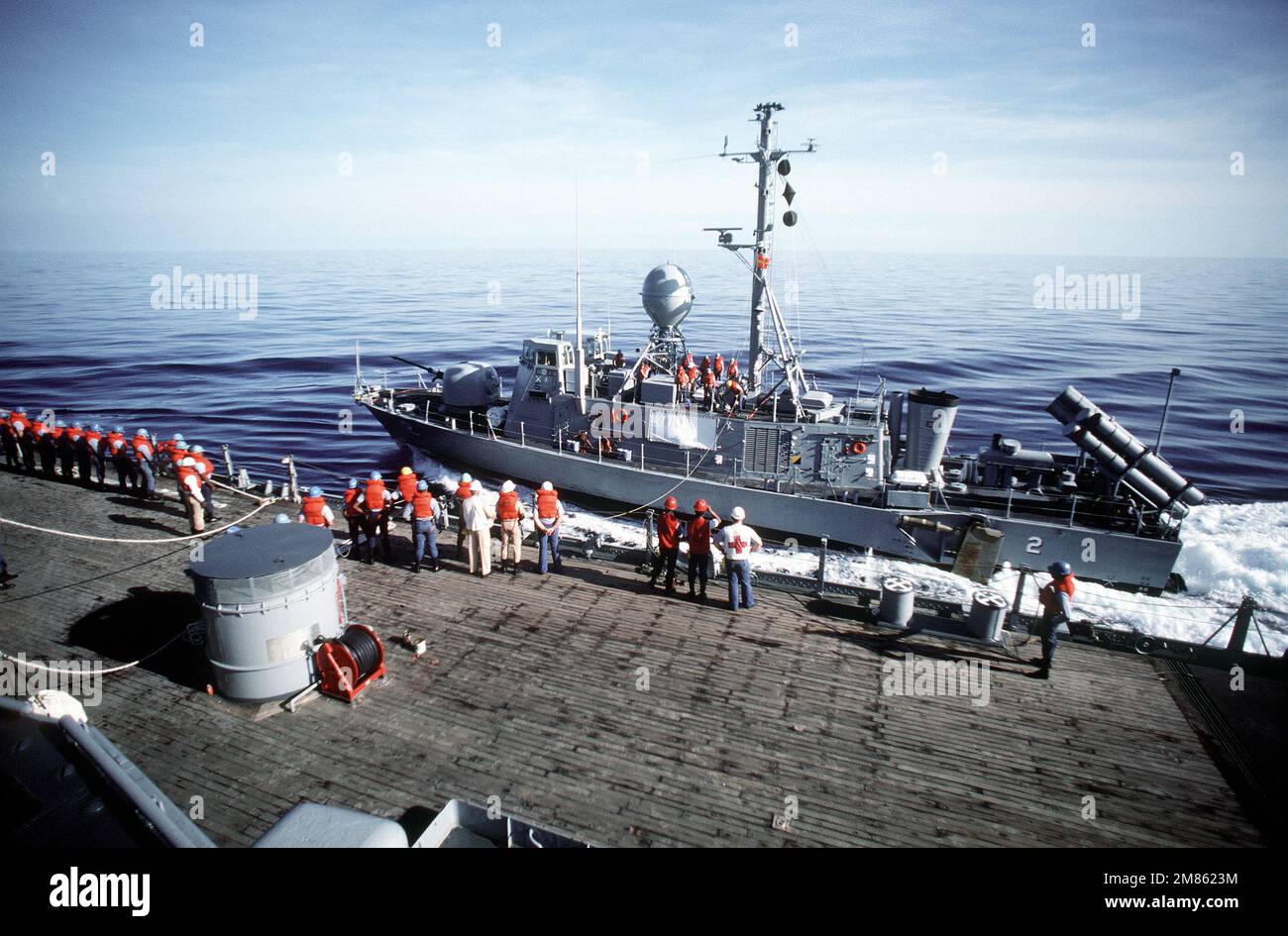 Crew members aboard the battleship USS IOWA (BB-61) watch from the rail ...