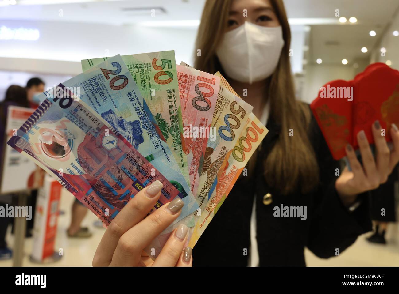 Staff Catherine Lau poses for a photo with new banknotes to the media ...