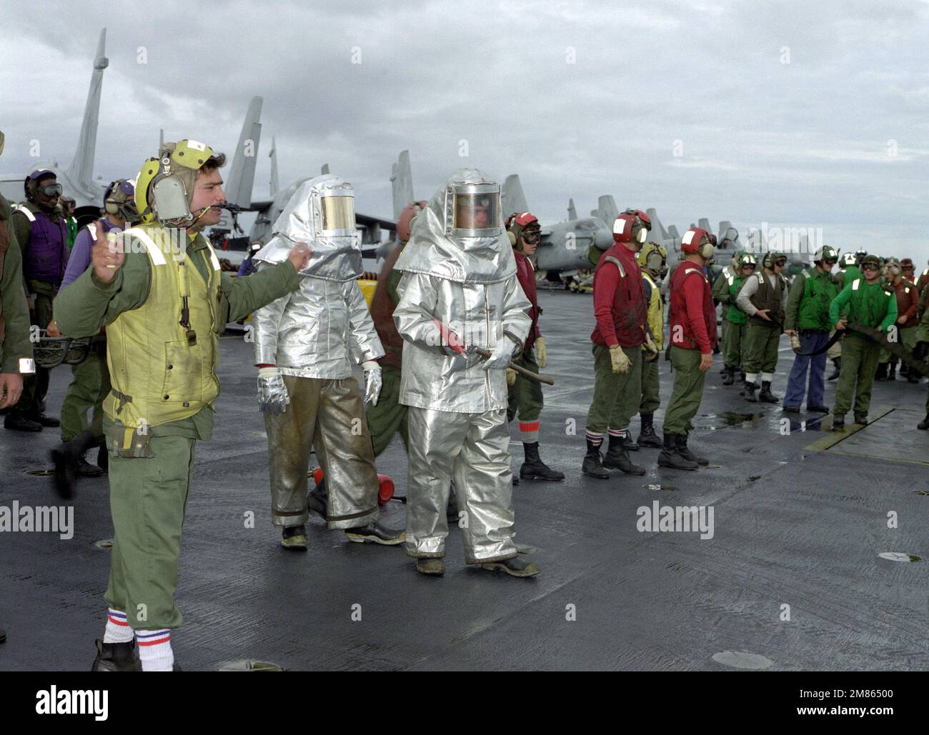Crew members wearing proximity suits participate in a general quarters ...