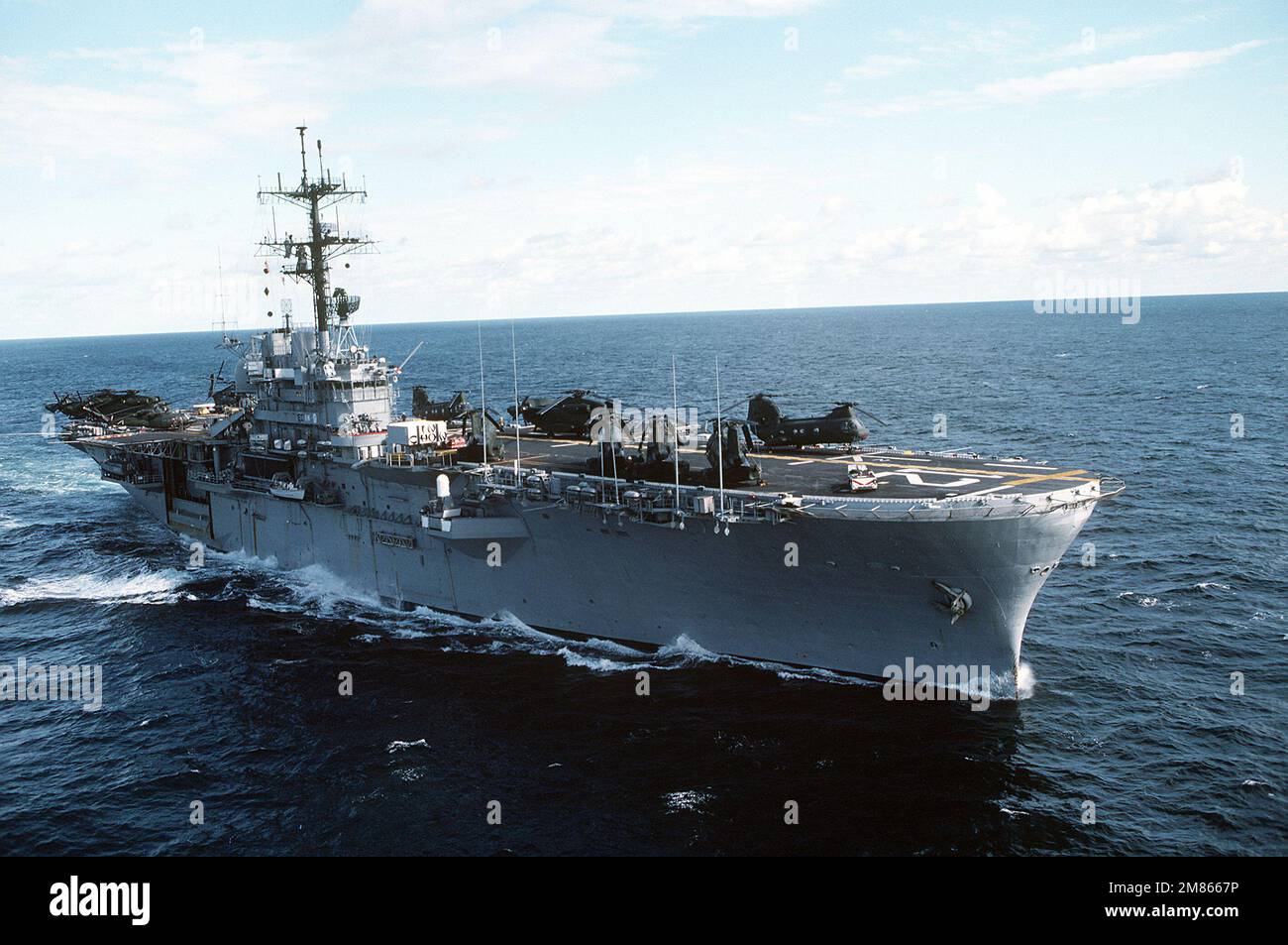 An elevated starboard bow view of the amphibious assault ship USS ...