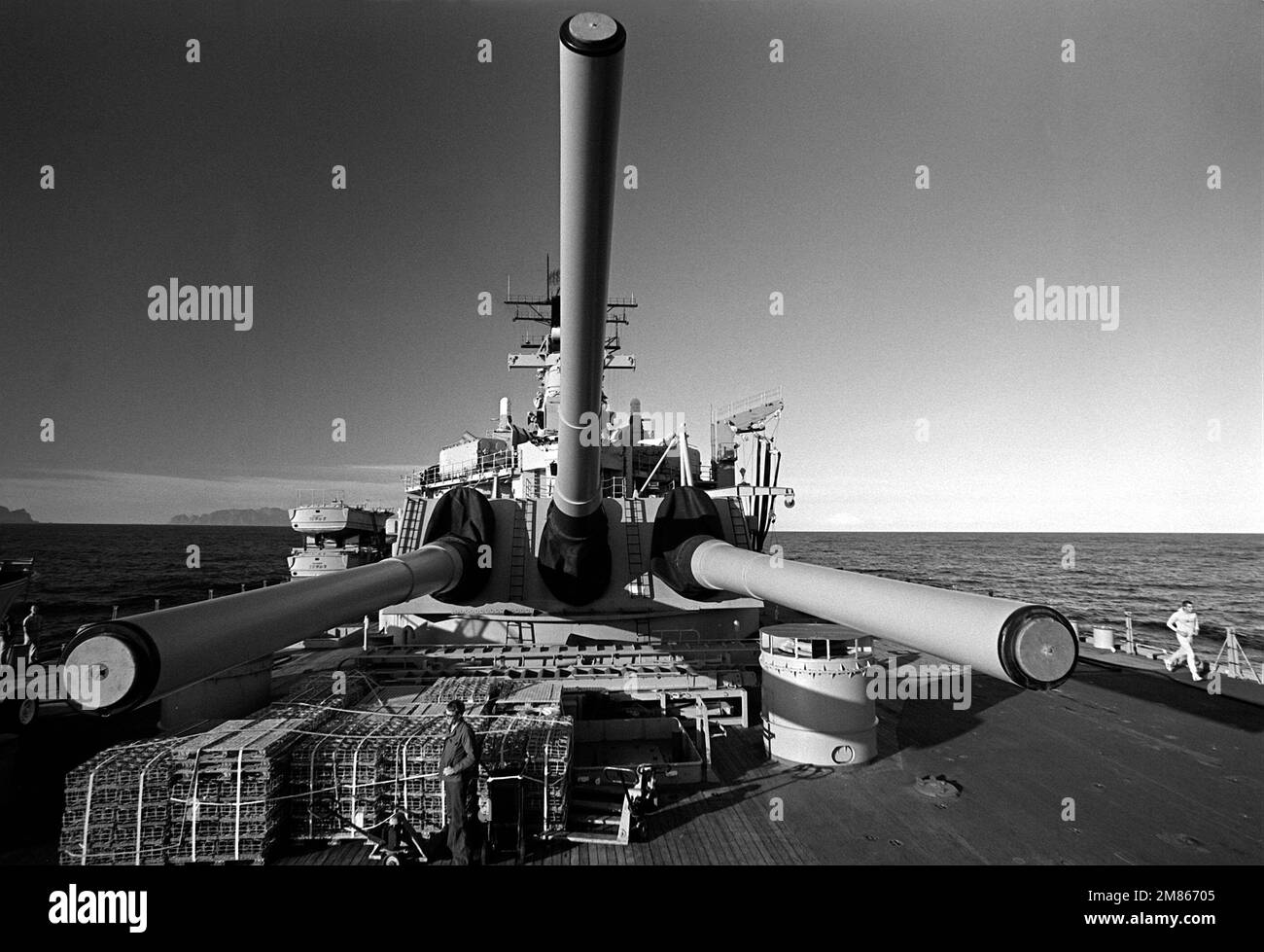 A crewman lines up pallets under the elevated center barrel of the No ...