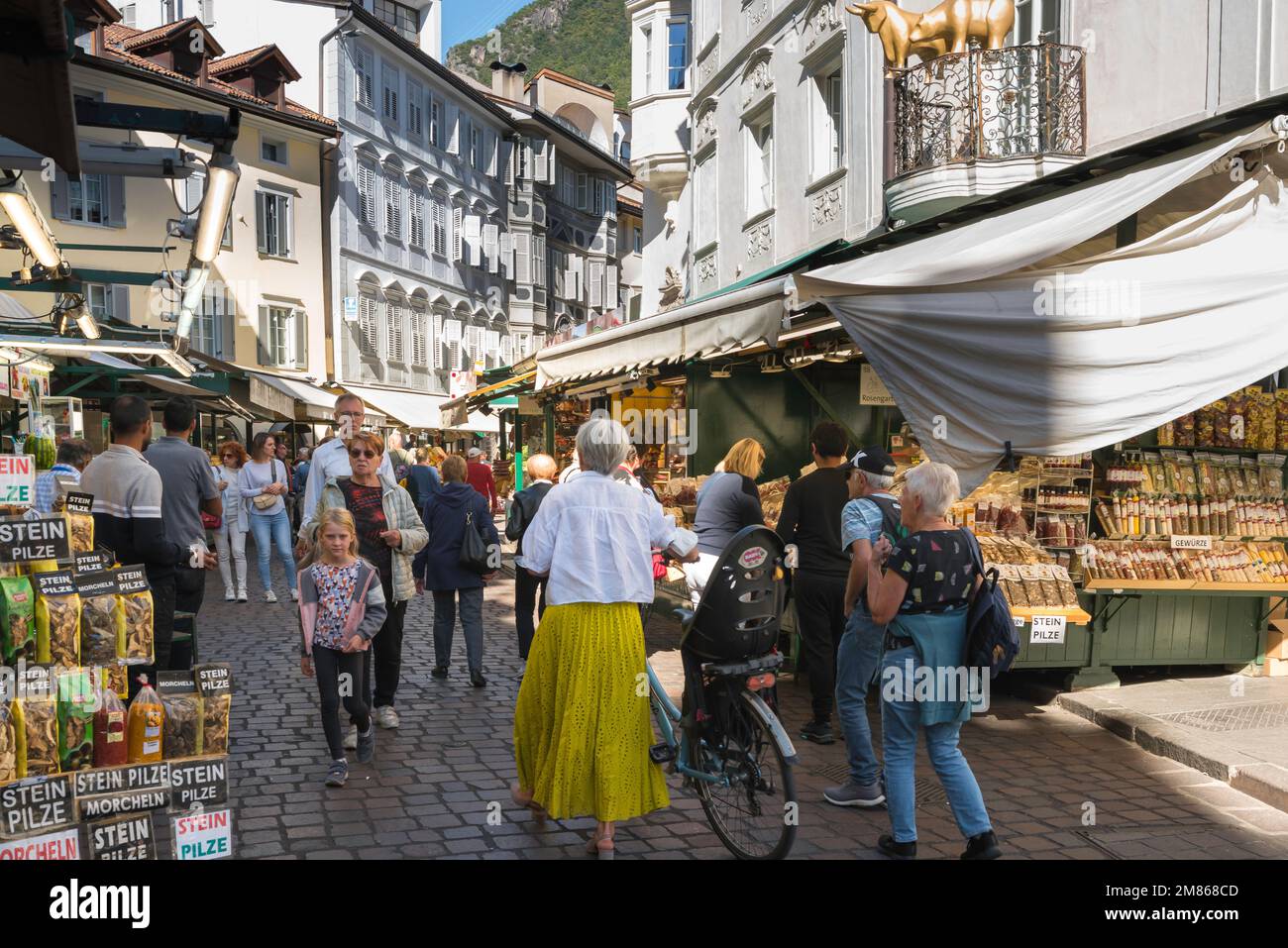 Bolzano market, view in summer of people walking past market stalls in ...