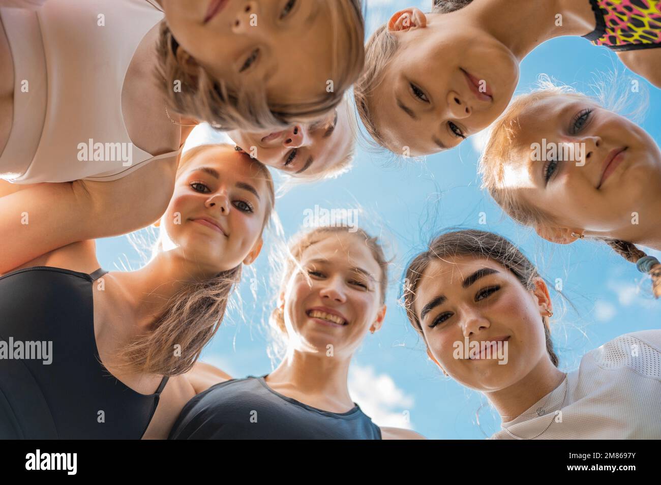 Group of children and young girls with female coach in the circle as ...