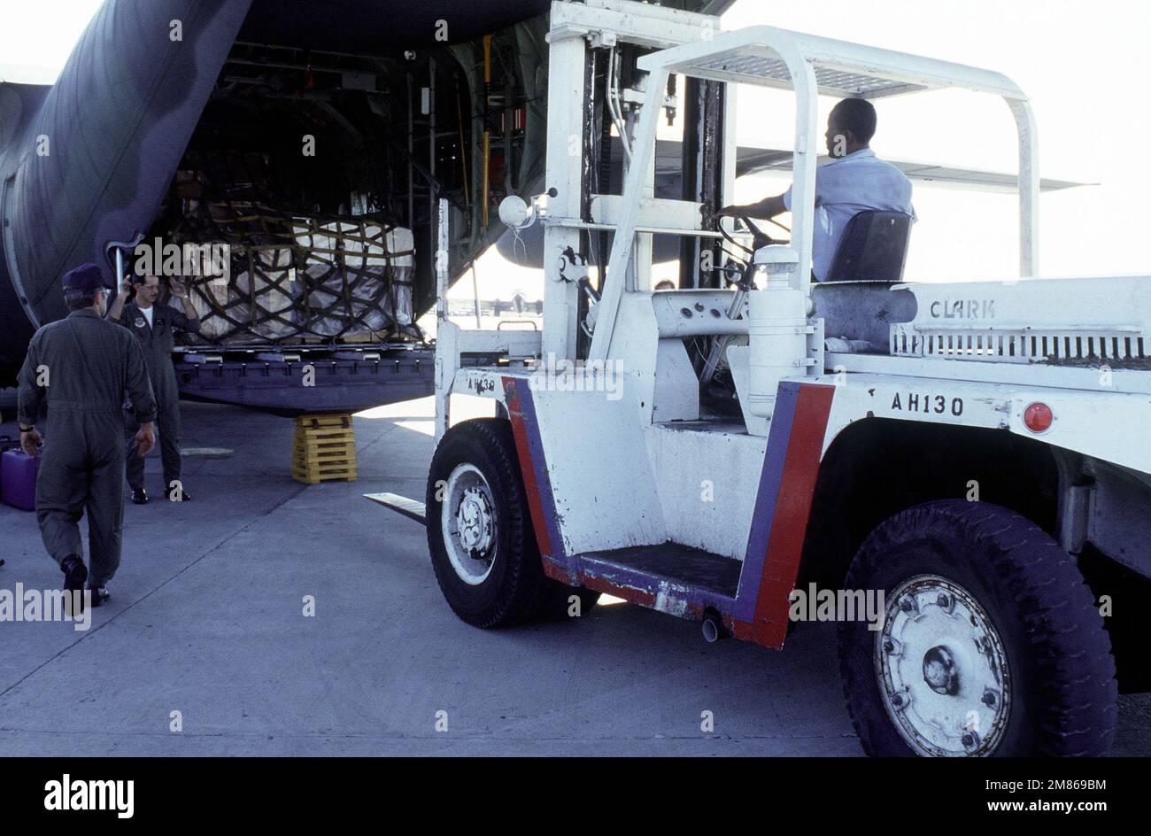 A forklift maneuvers in back of a 357th Tactical Airlift Squadron C ...