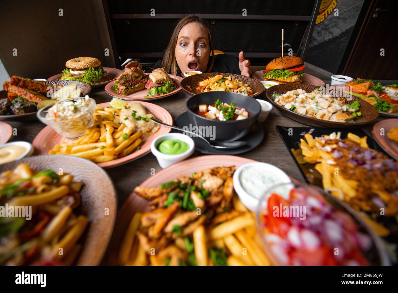 Hungry woman stare on table full of delicious food in plates with open ...