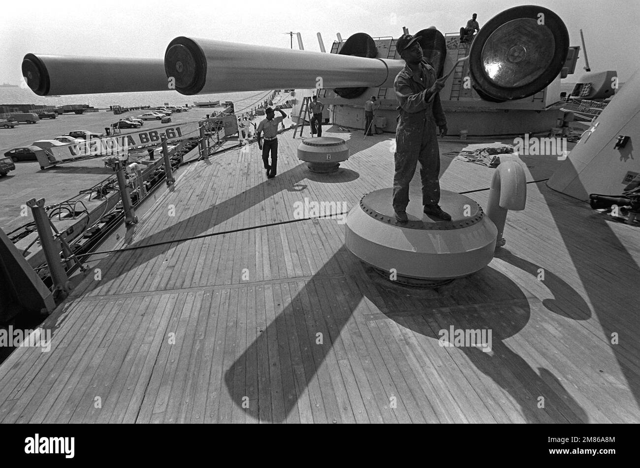 A gunner's mate paints the barrel of one of the No. 2 Mark 7 16-inch/50 ...