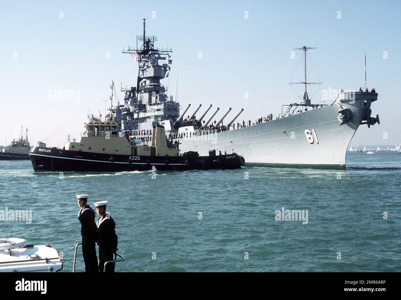 The battleship USS IOWA (BB-61) is assisted into port by the British twin unit tractor tugs ...