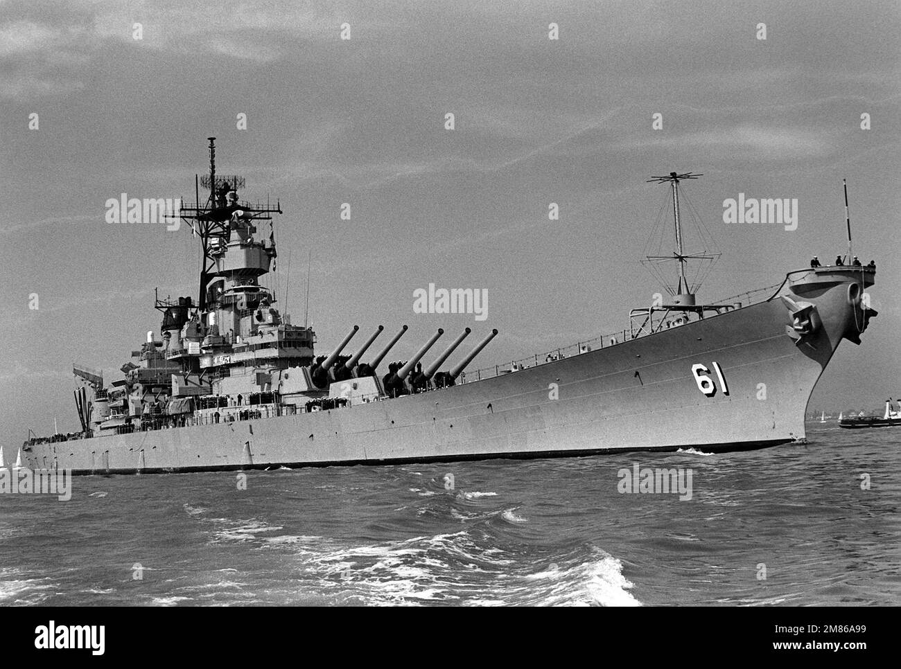 Starboard bow view of the battleship USS IOWA (BB-61) being escorted ...