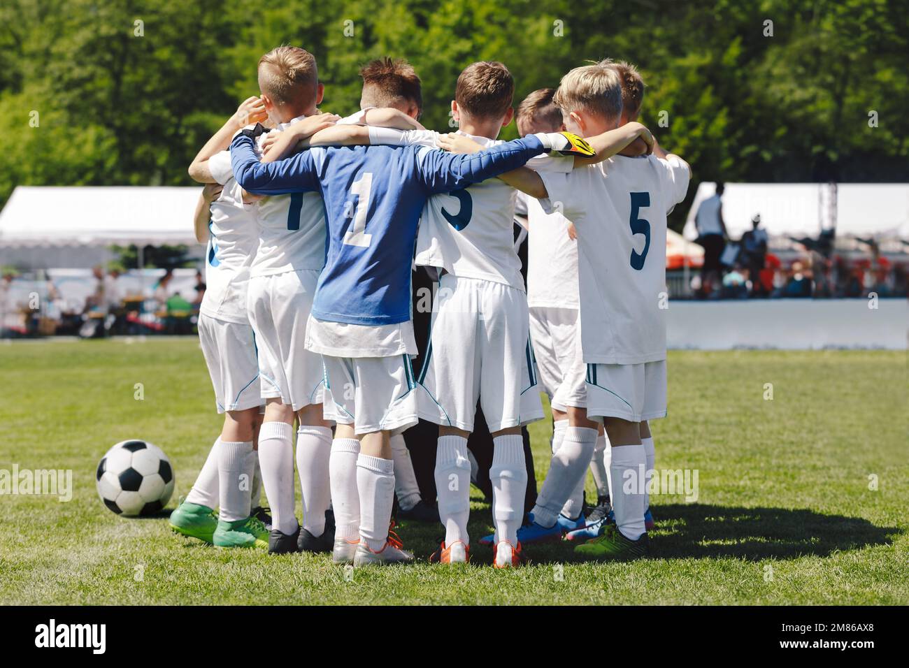 Group of teenage school boys huddling in soccer team and huddle before the final football match ...