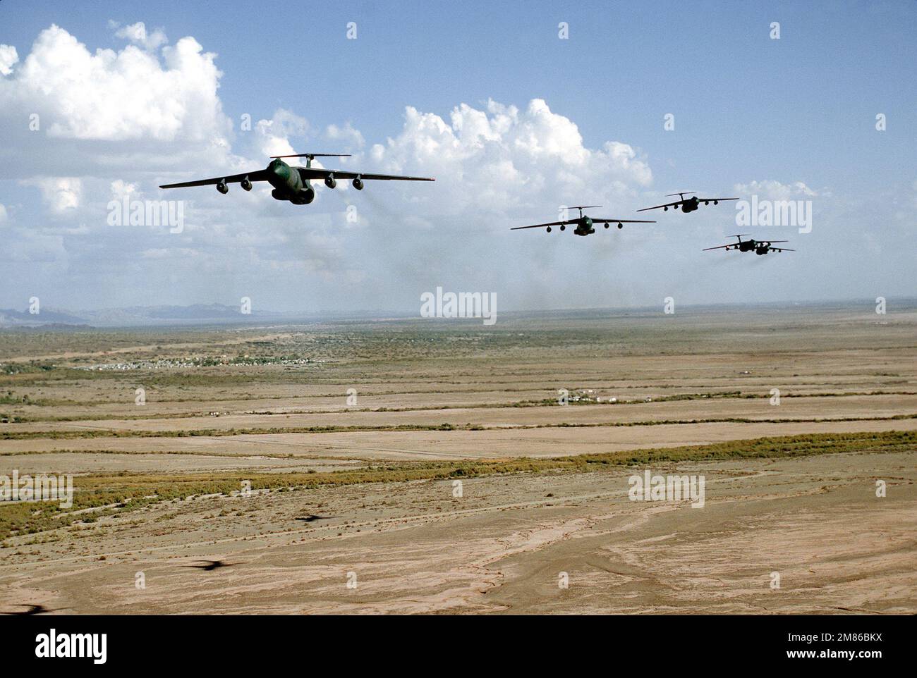 Air to air front view of a flight of four C-141 Starlifters, assigned ...