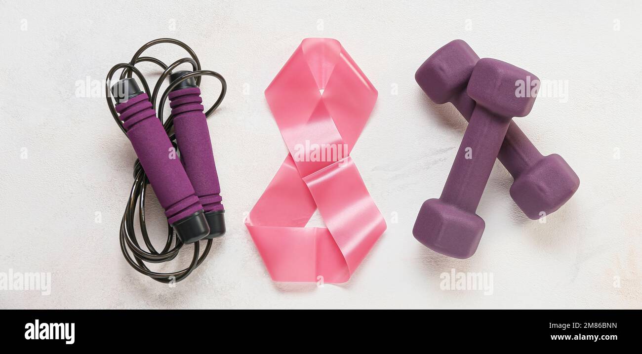 Composition with skipping rope, elastic band and dumbbells on white ...