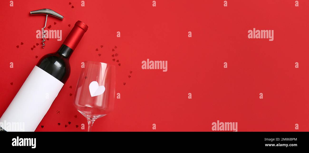 Bottle of wine, glass, confetti and corkscrew on red background with ...