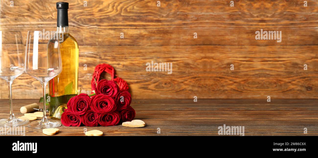 Bottle of wine, rose flowers and glasses on wooden background with ...