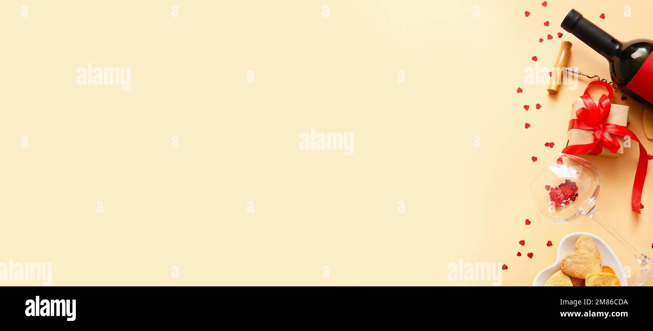 Composition with bottle of wine, glass and gift box on beige background ...