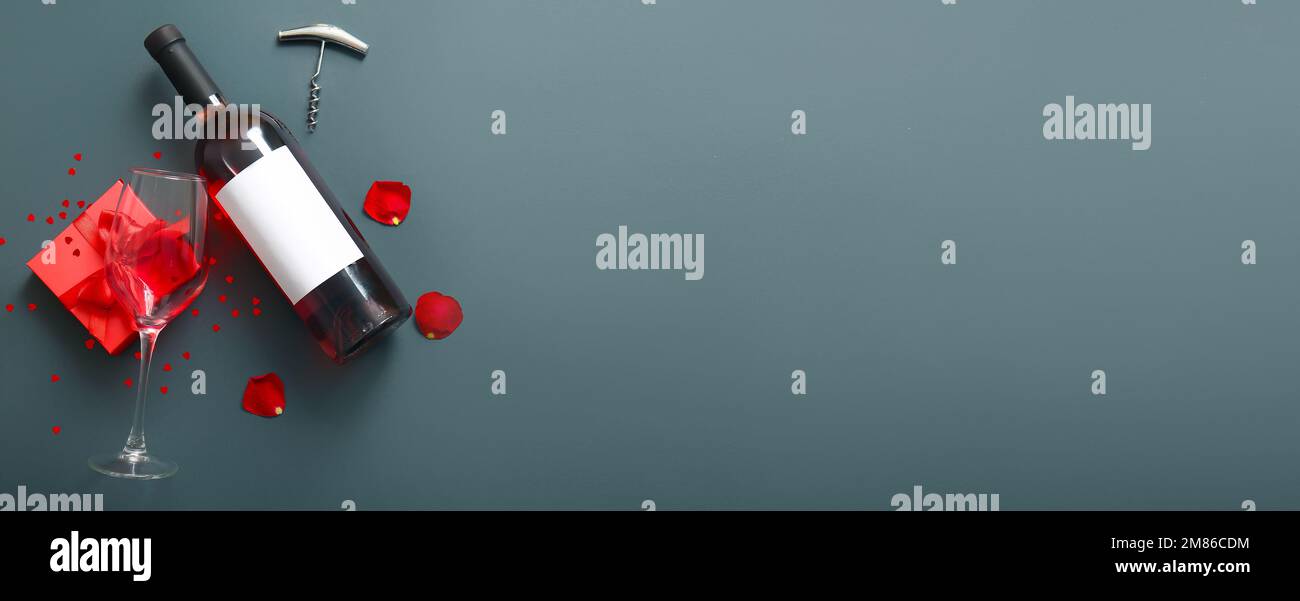 Composition with bottle of wine, glass, gift and corkscrew on grey ...