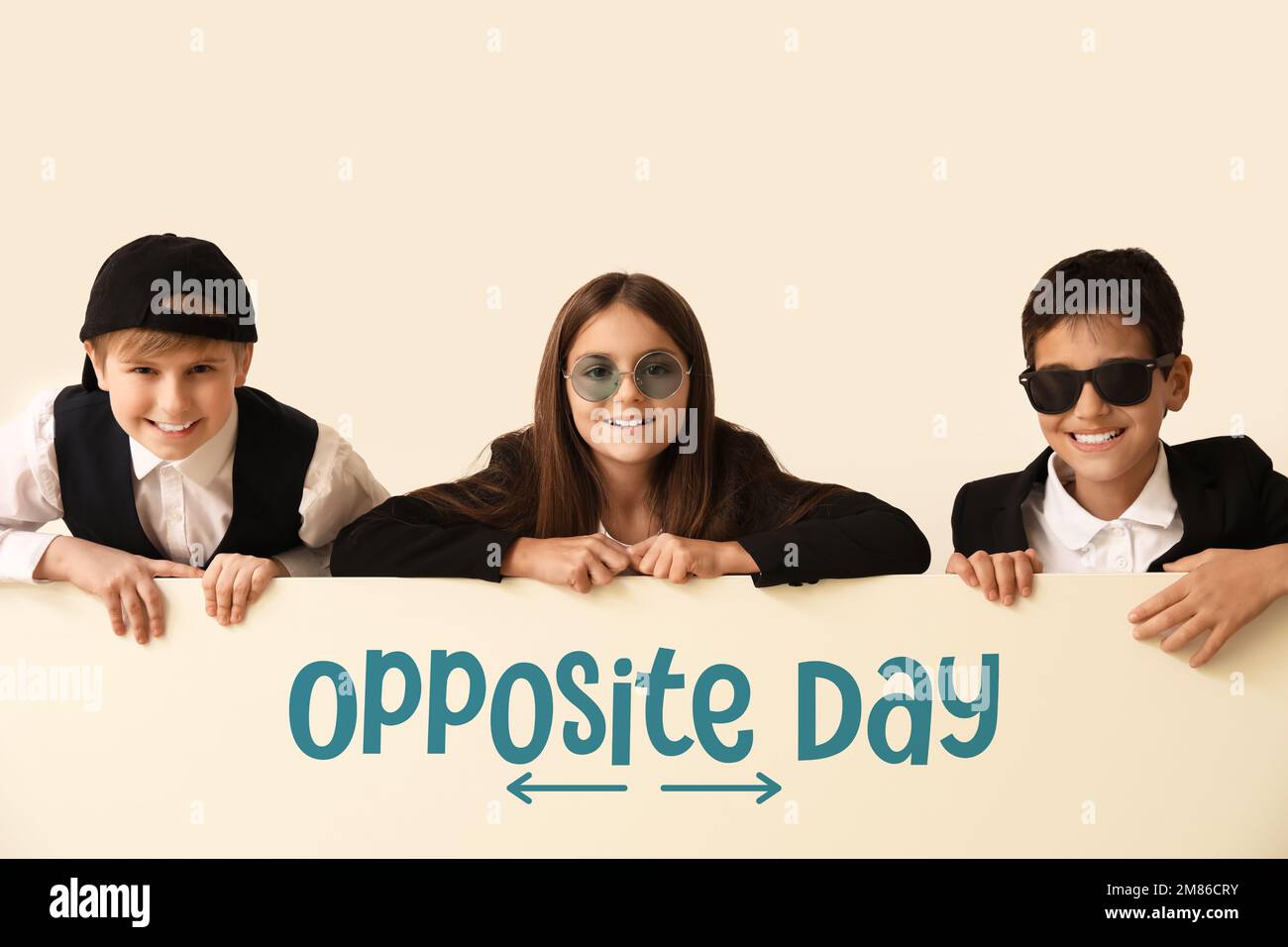 Little children and big poster with text NATIONAL OPPOSITE DAY on light ...