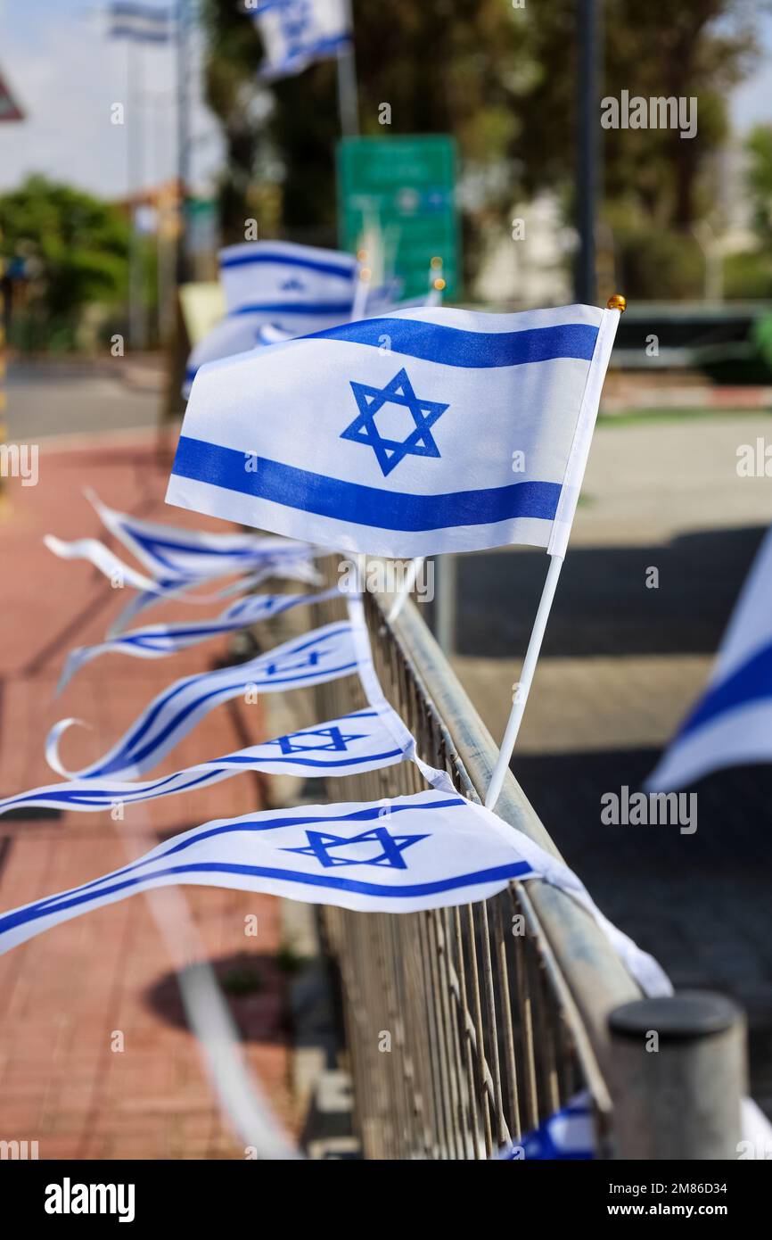 Fence with flags of Israel on city street, closeup Stock Photo - Alamy