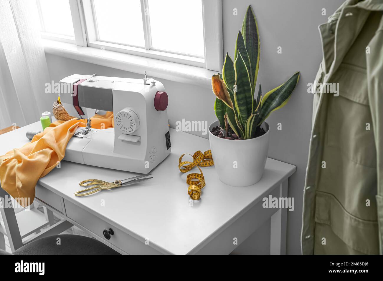 Tailor's workplace with sewing machine and houseplant near window Stock ...