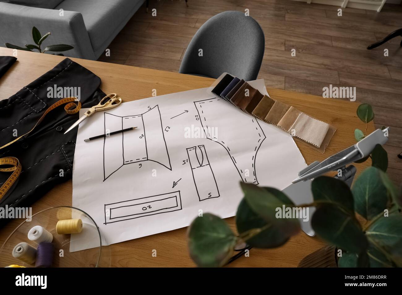 Tailor's workplace with sewing pattern and supplies in modern atelier ...