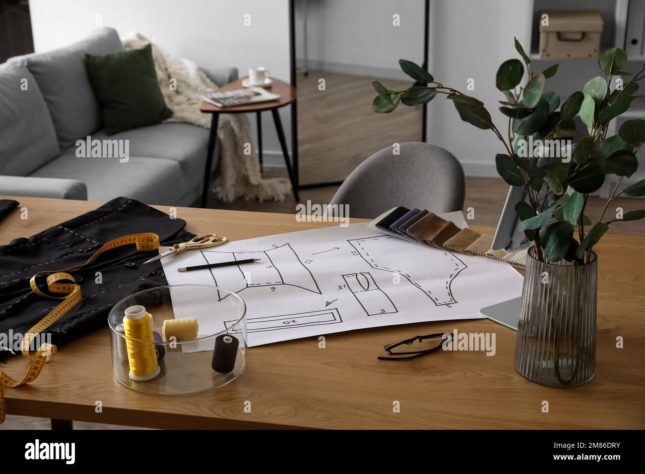 Tailor's workplace with sewing pattern and supplies in modern atelier ...