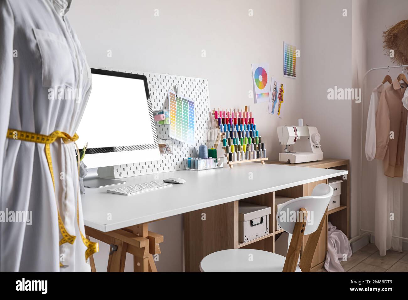 Tailor's workplace with computer and threads in modern atelier Stock ...