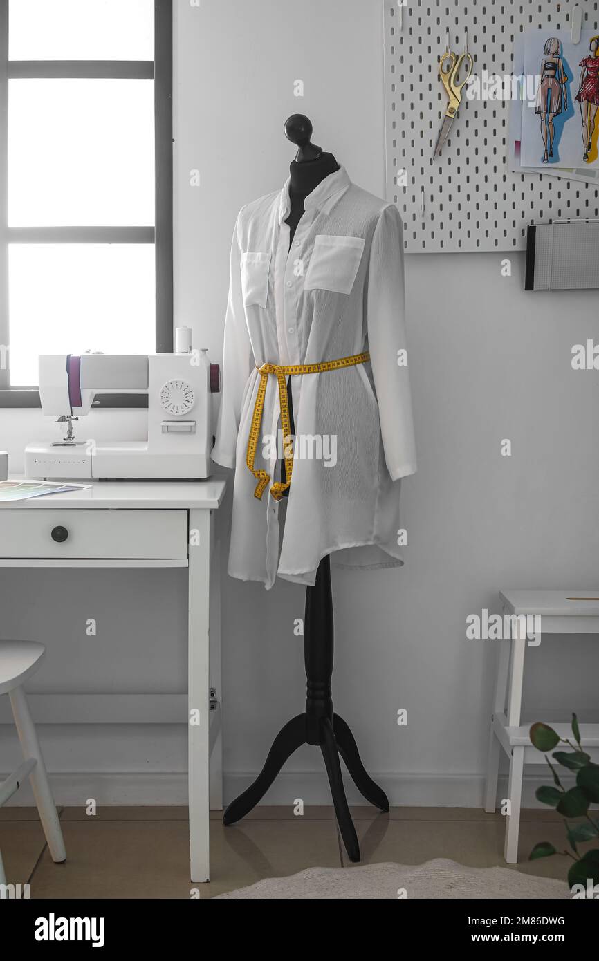 Interior of modern atelier with workplace and mannequin Stock Photo - Alamy
