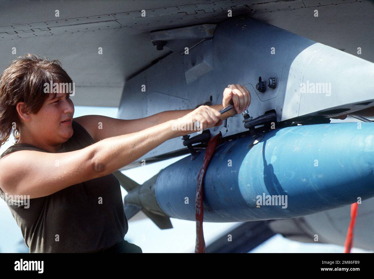 An airman from the 8th Aircraft Generation Squadron secures an inert ...