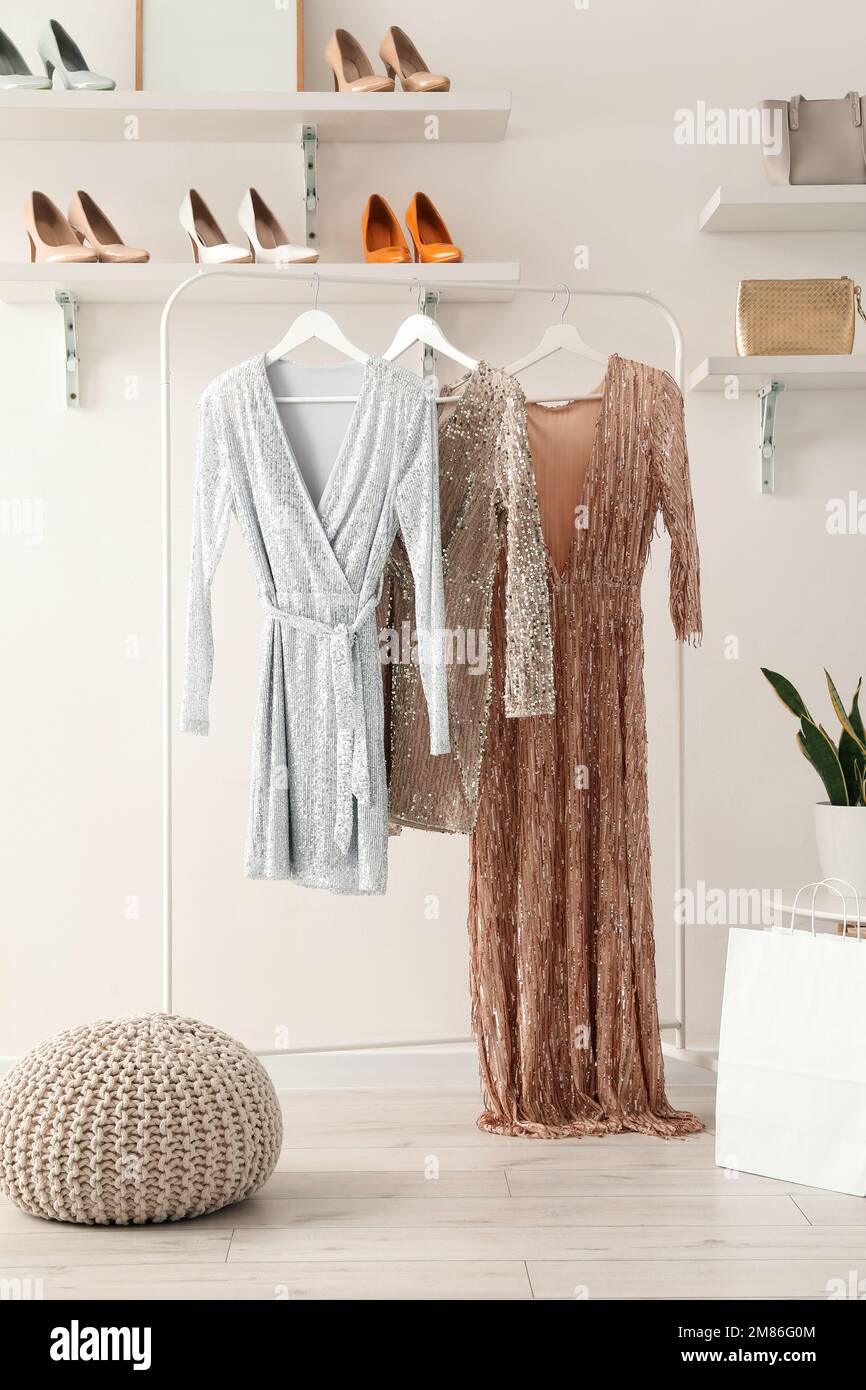 Rack with stylish female dresses in dressing room Stock Photo - Alamy