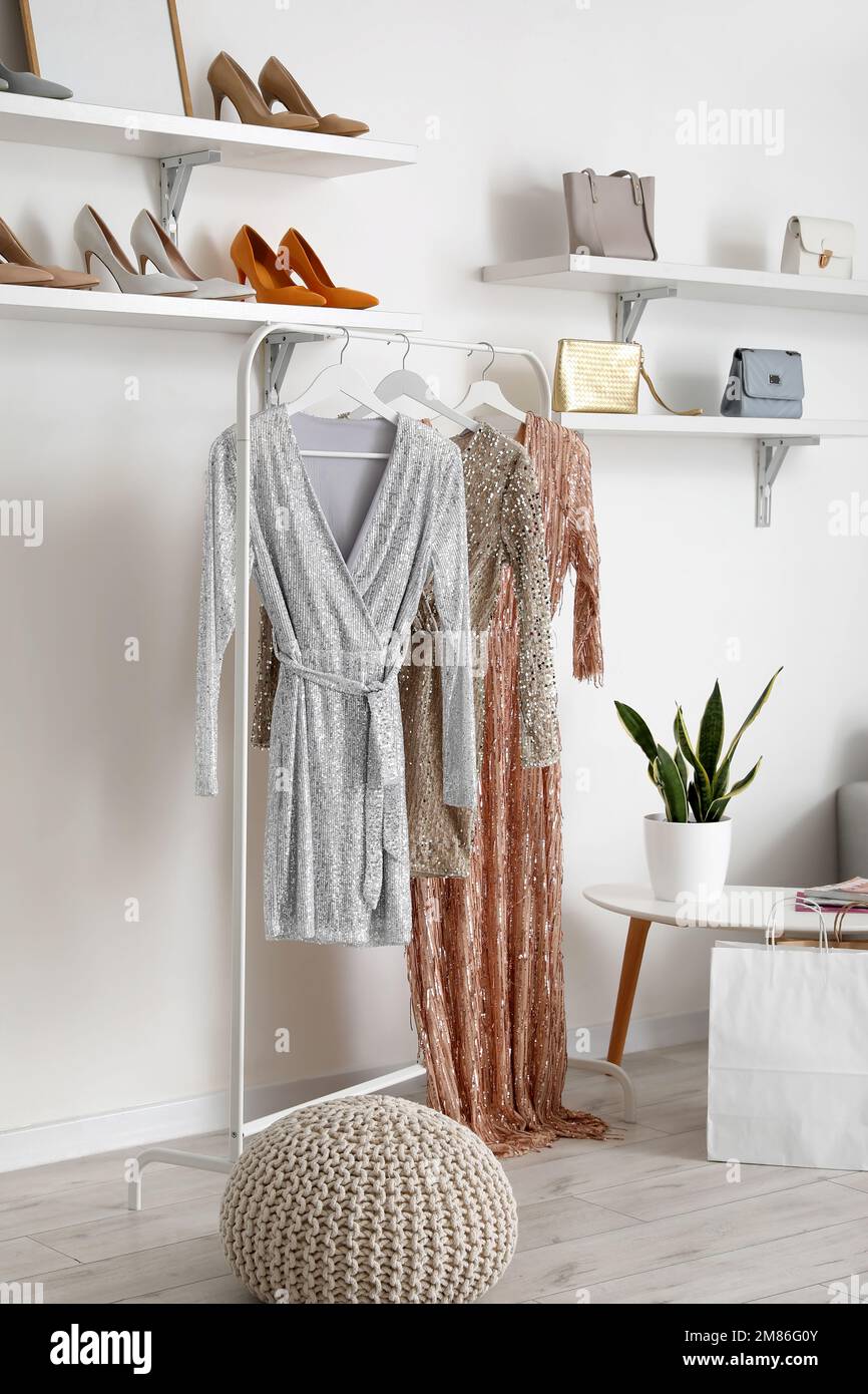 Rack with stylish female dresses in dressing room Stock Photo - Alamy