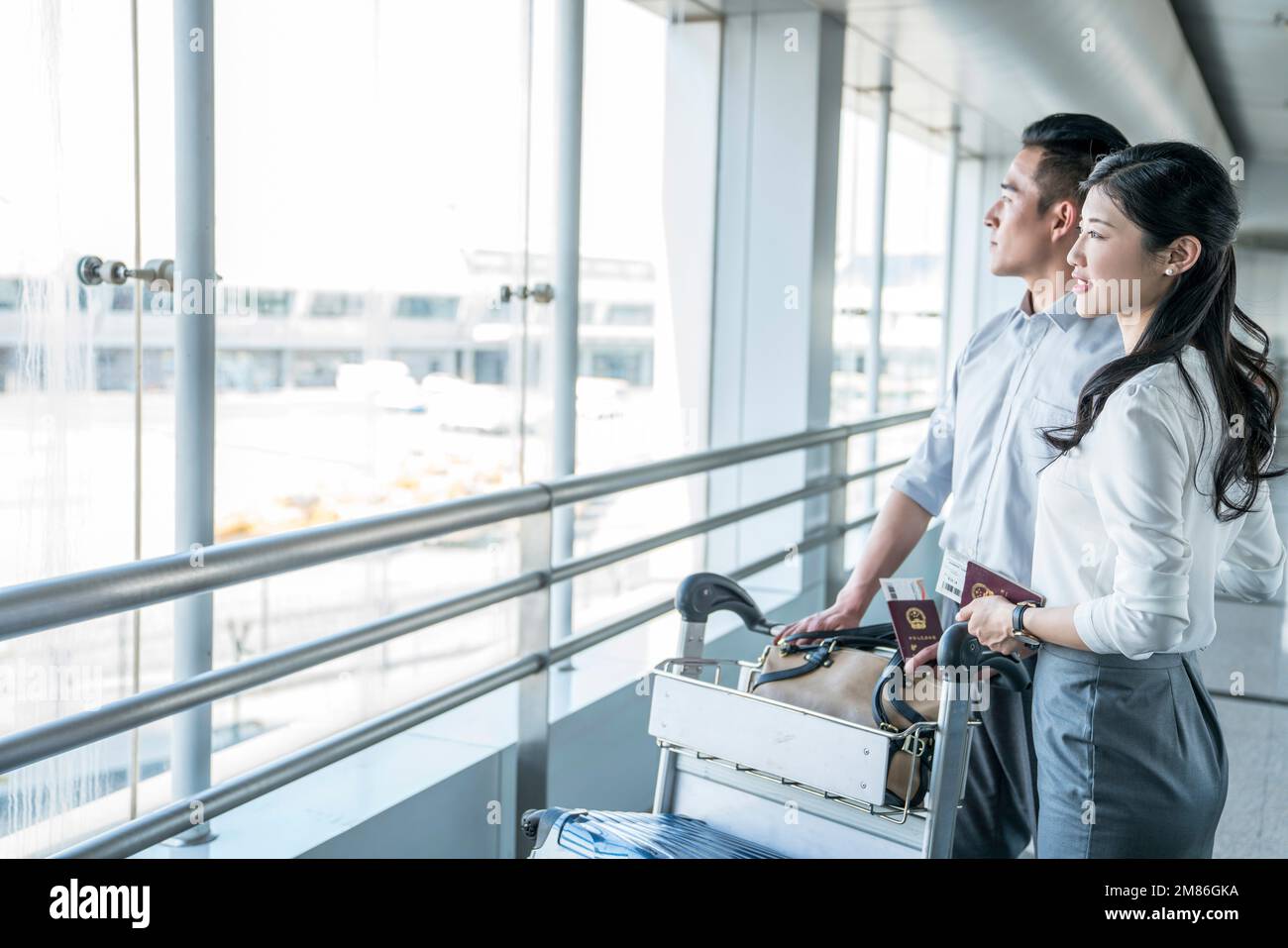 Business people pushing baggage at the airport Stock Photo - Alamy