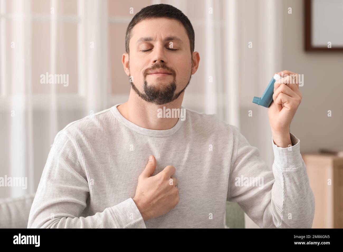 Happy man after using inhaler at home Stock Photo - Alamy