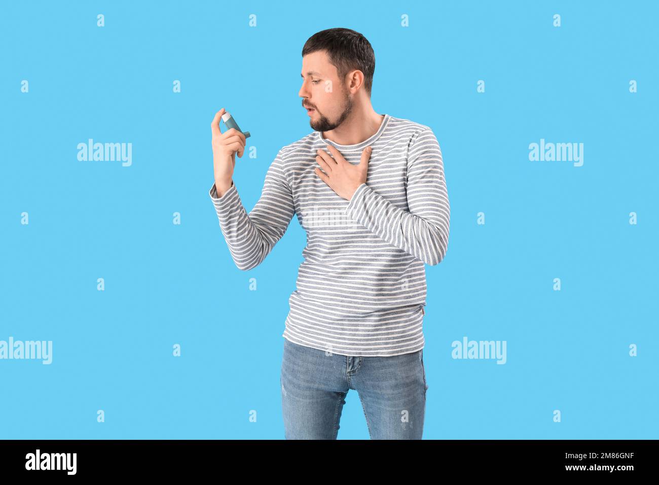 Sick man with inhaler on blue background Stock Photo - Alamy