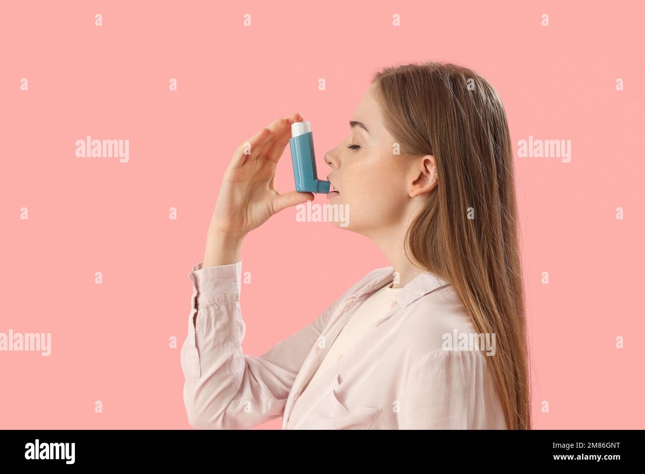 Sick young woman with inhaler on pink background Stock Photo - Alamy