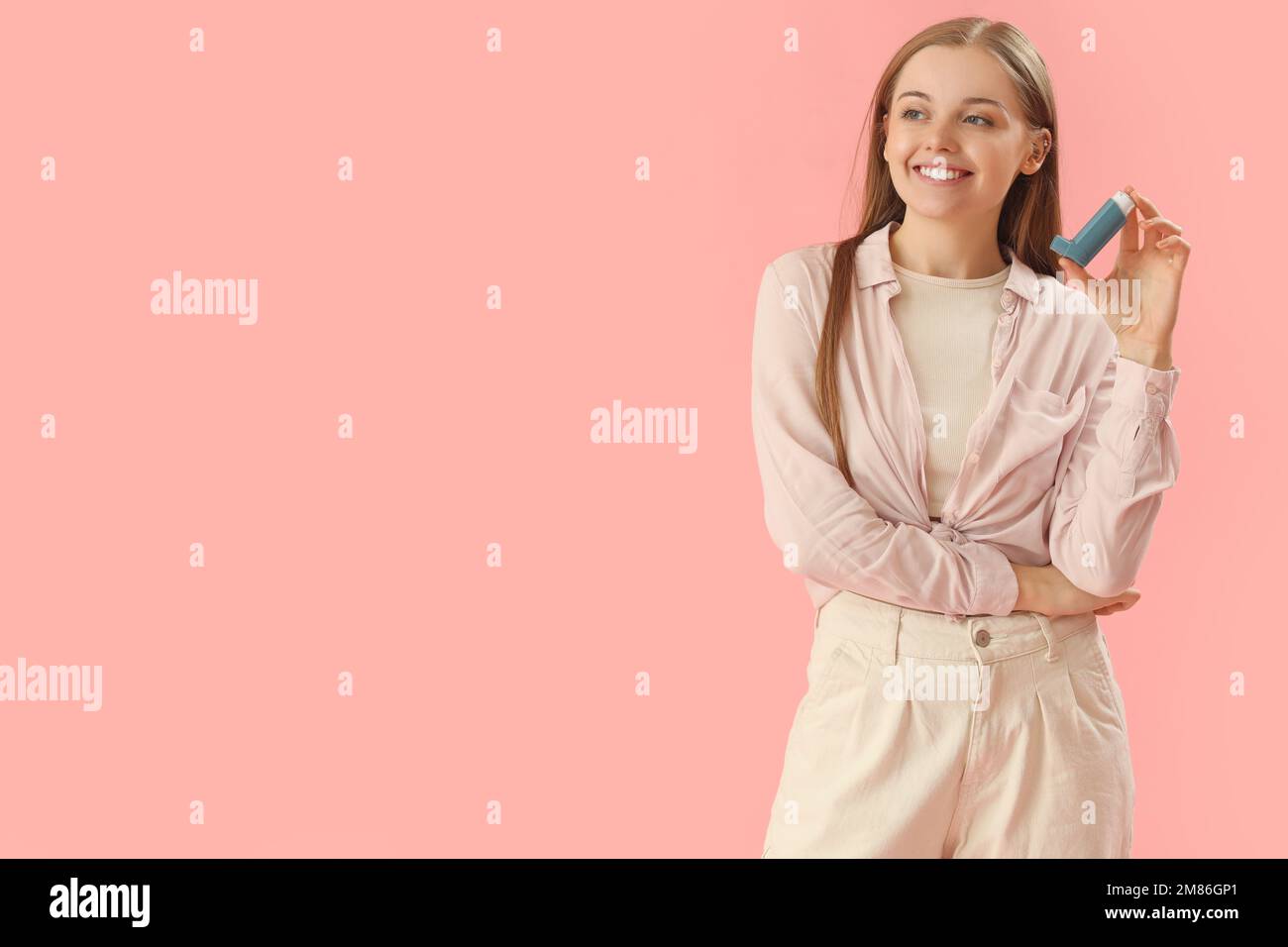 Young woman with inhaler on pink background Stock Photo - Alamy
