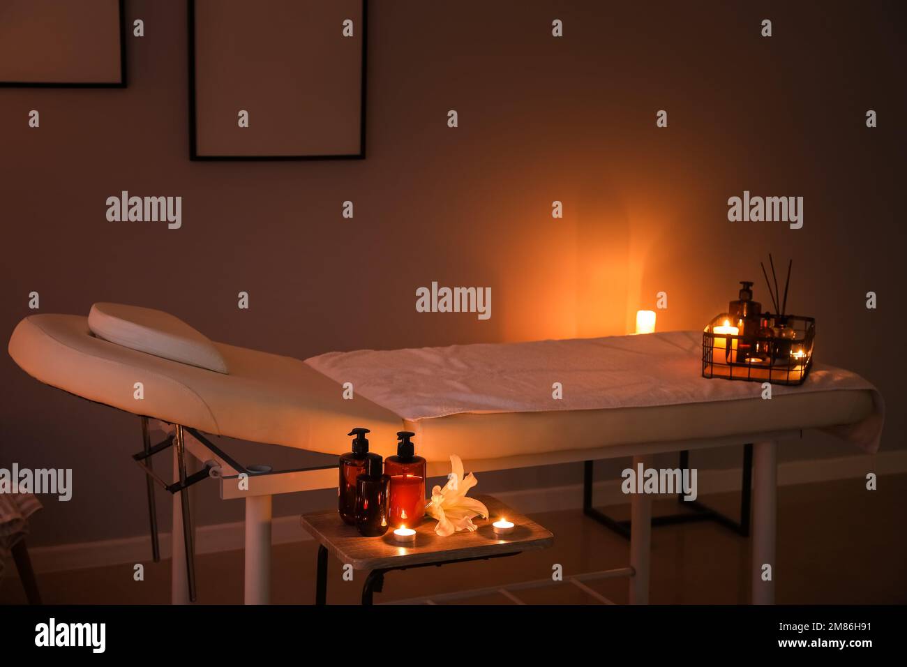 Interior of dark spa salon with couch, table and burning candles Stock ...