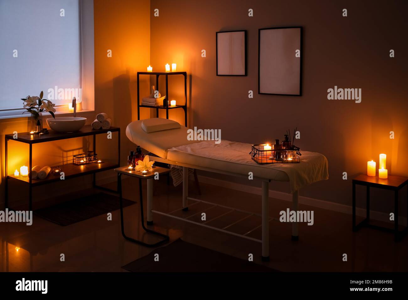 Interior of dark spa salon with couch, tables and burning candles Stock ...