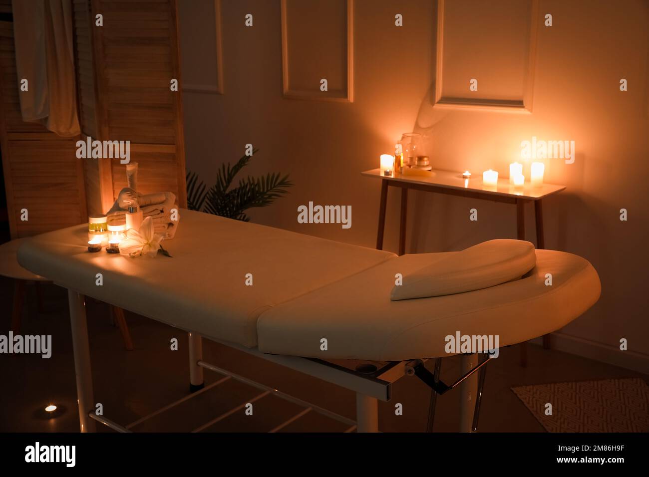 Interior of dark spa salon with couch, burning candles and table Stock ...