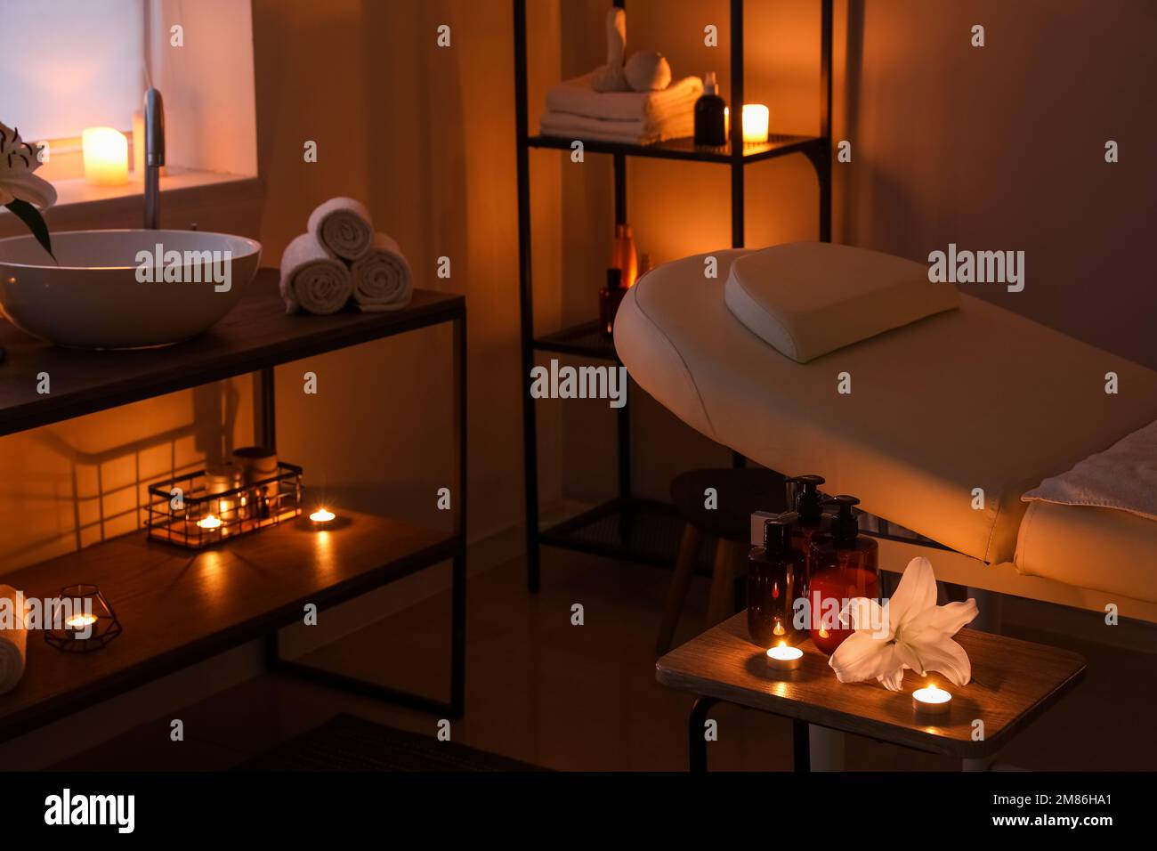 Interior of dark spa salon with couch, tables and burning candles Stock ...