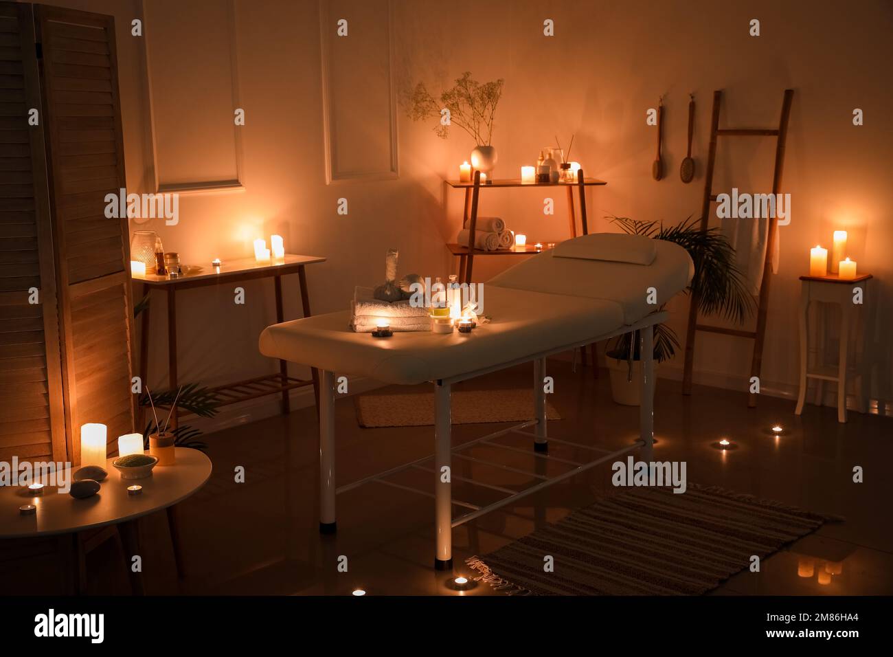 Interior of dark spa salon with couch, burning candles and table Stock ...